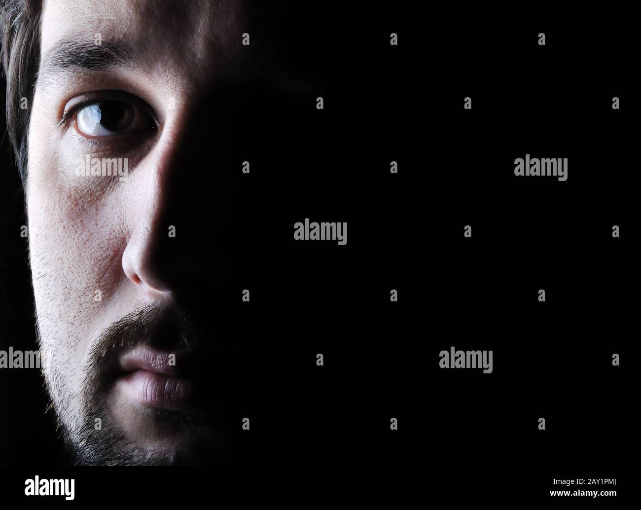 Low-key portrait - half face - sad and angry looking man Stock Photo ...