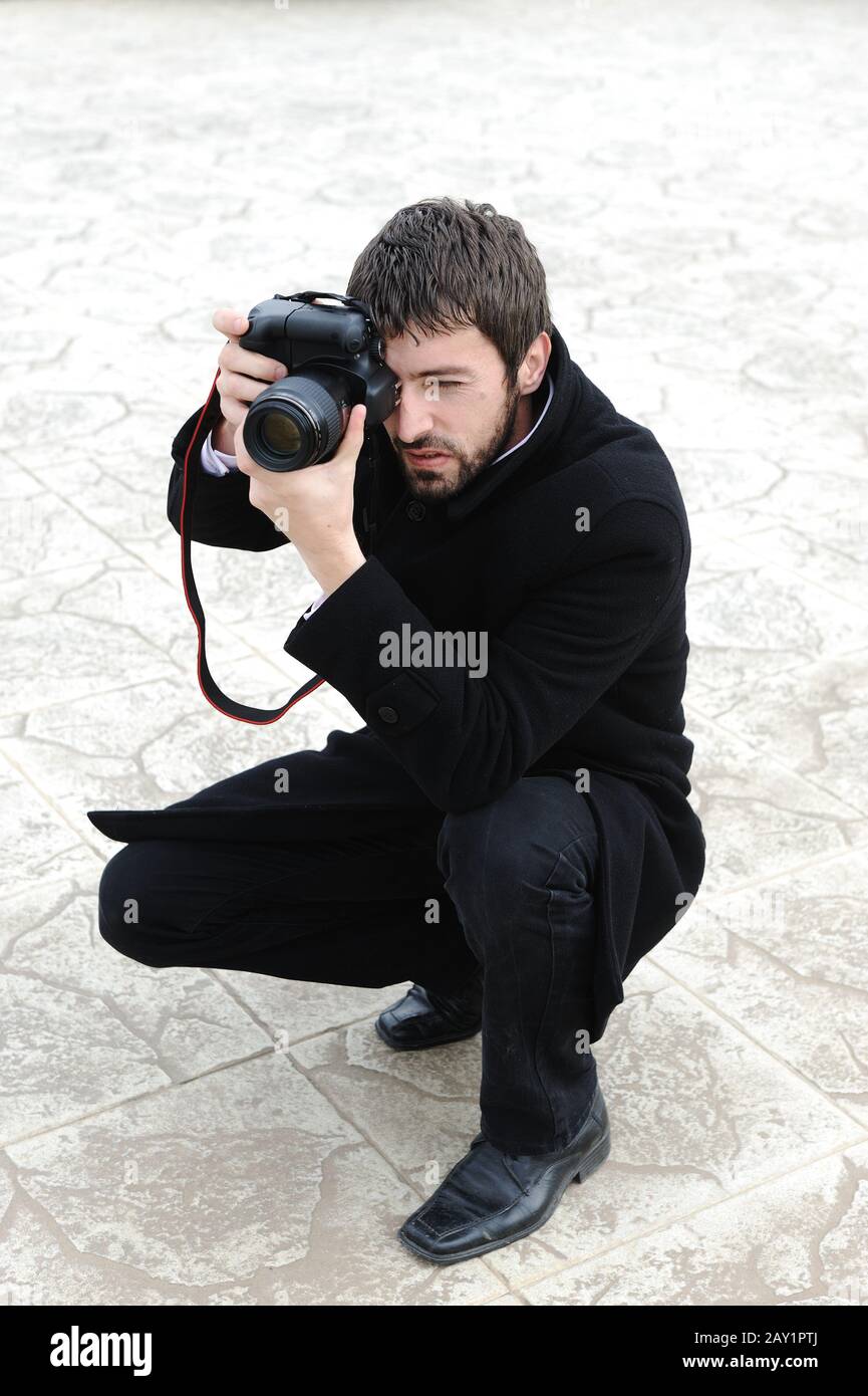 Young professional man with camera shooting outdoor Stock Photo - Alamy