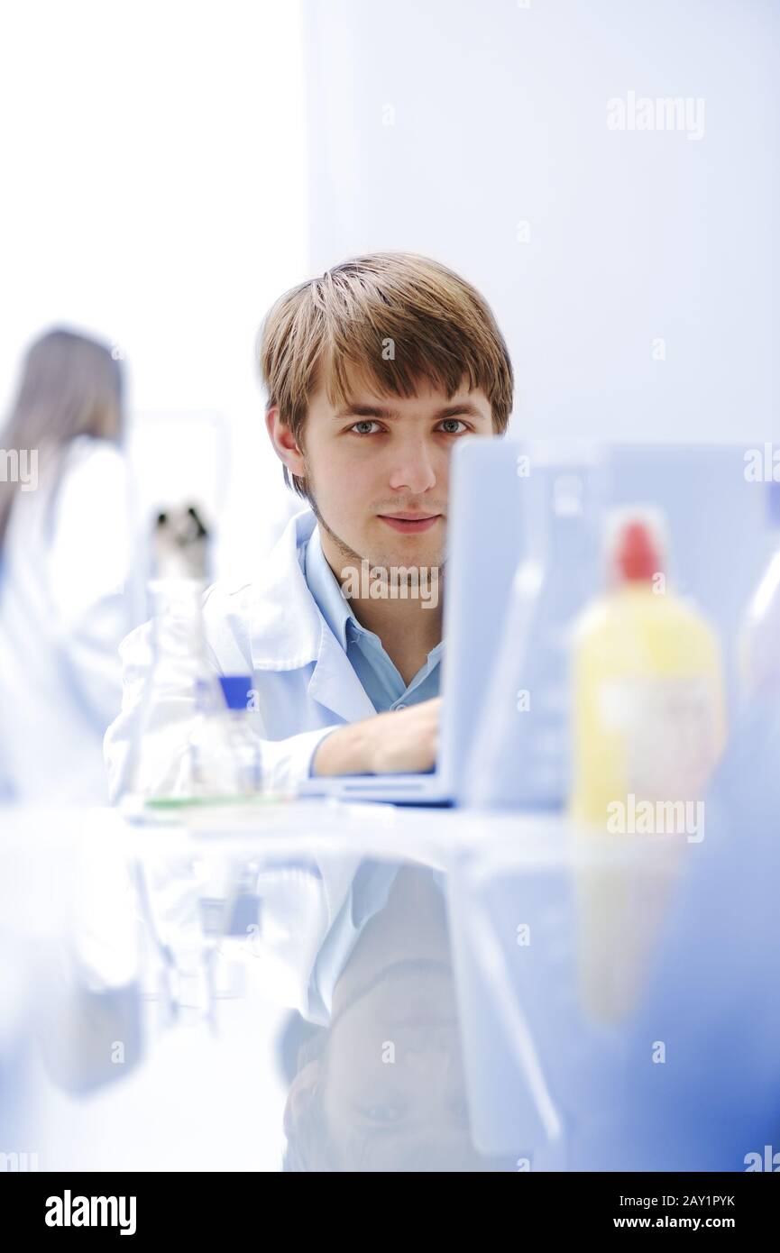 Young male scientist in lab with laptop Stock Photo - Alamy