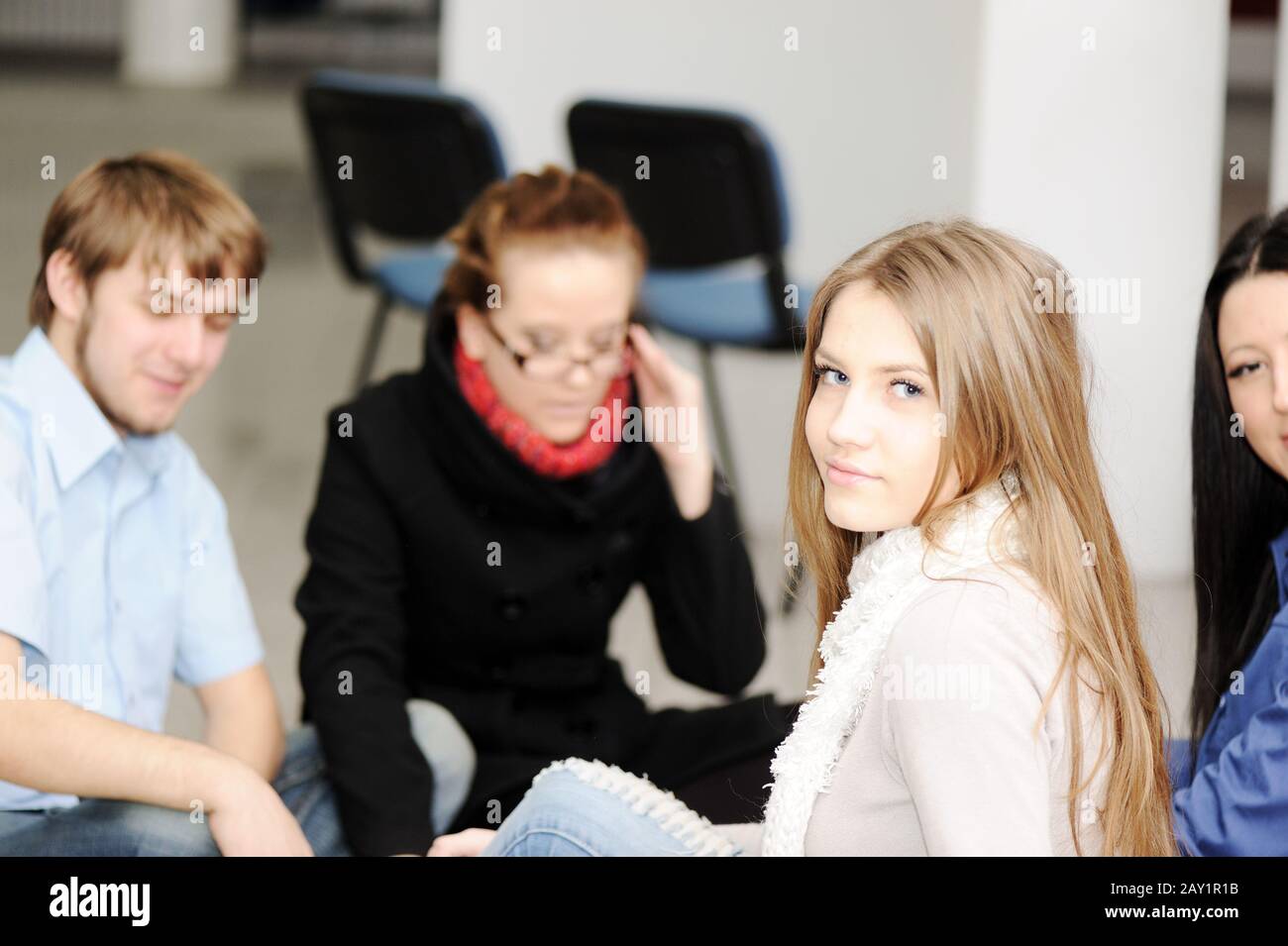 Group of four students outside sitting on floor inside Stock Photo - Alamy