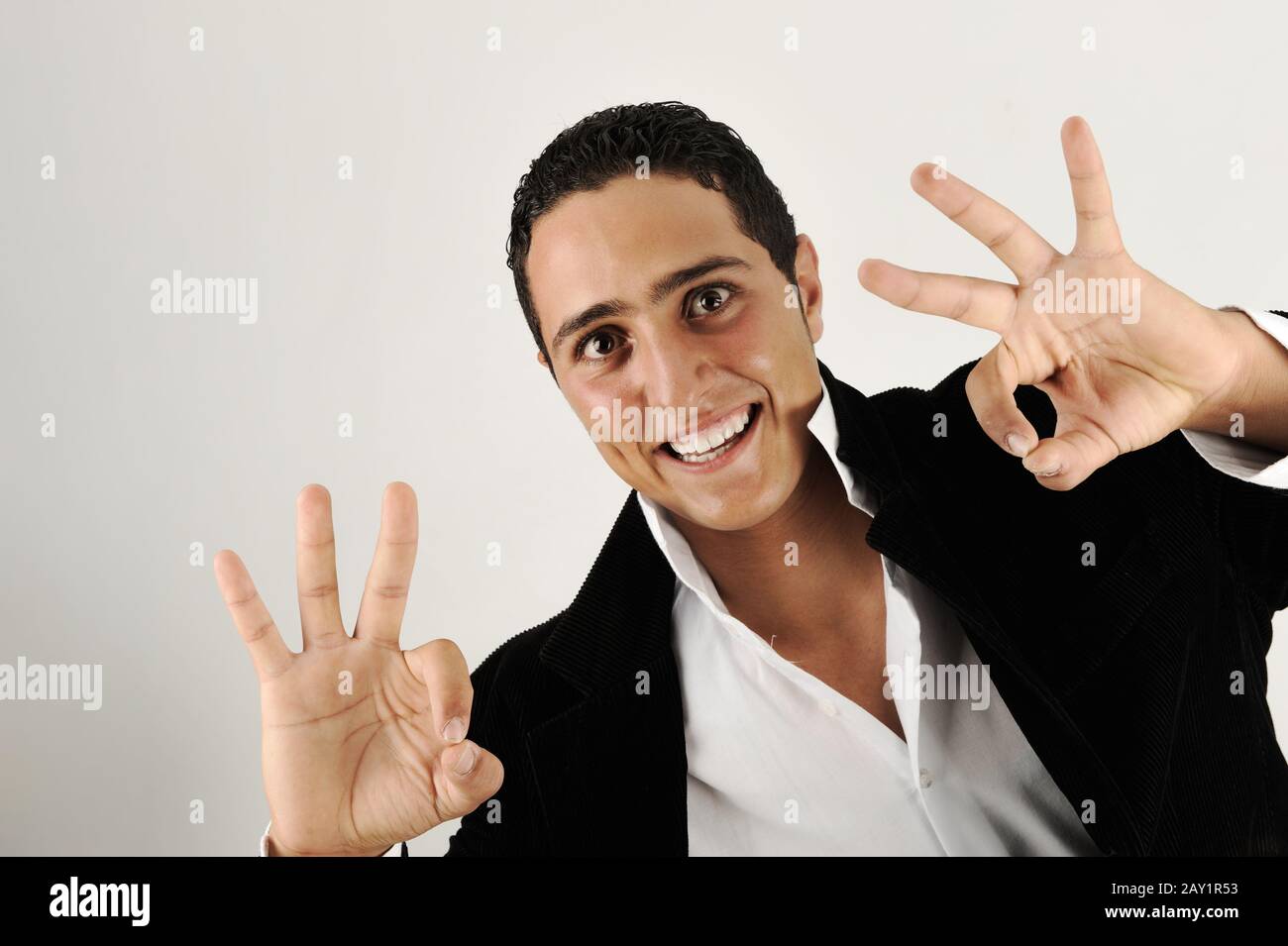 Closeup of good looking young man gesturing okay sign over white ...
