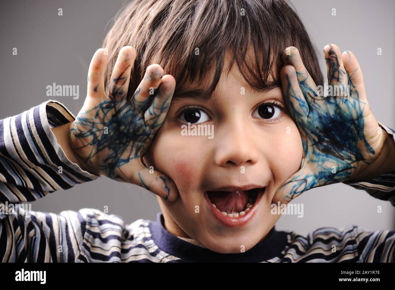 Excited little boy with messy color hands Stock Photo - Alamy