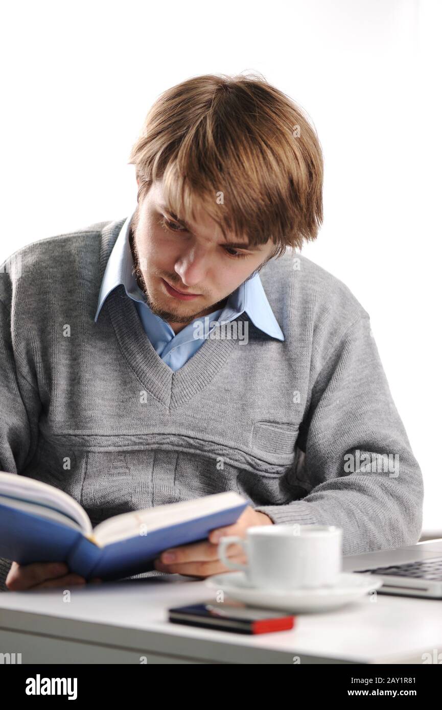Student reading book on desk Stock Photo - Alamy