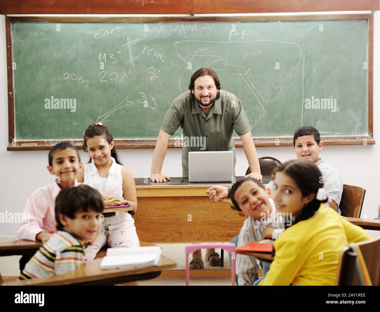 Teacher in classroom with his little happy students Stock Photo - Alamy