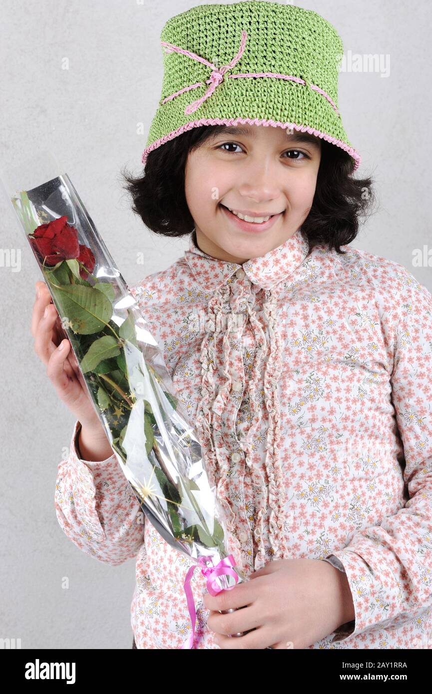 Cute little girl holding red rose Stock Photo - Alamy