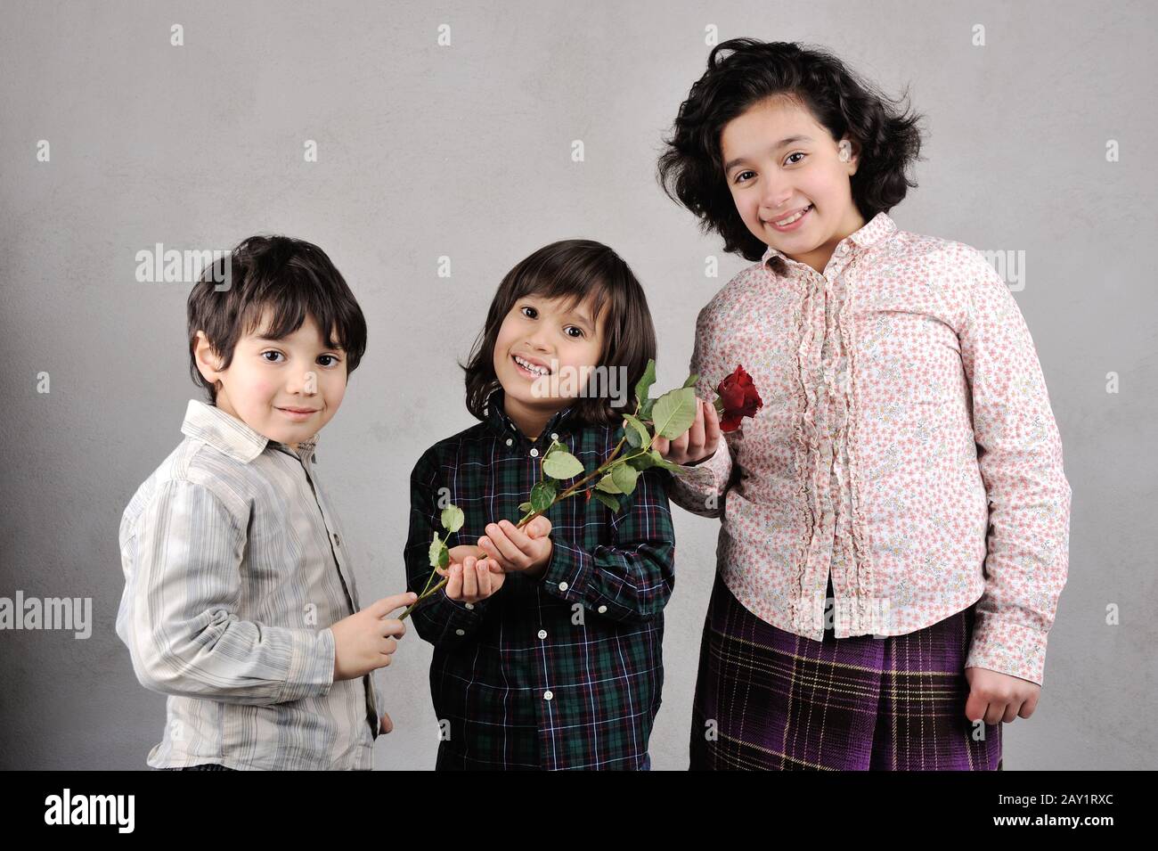 Two brothers and sister with beautiful red rose Stock Photo - Alamy
