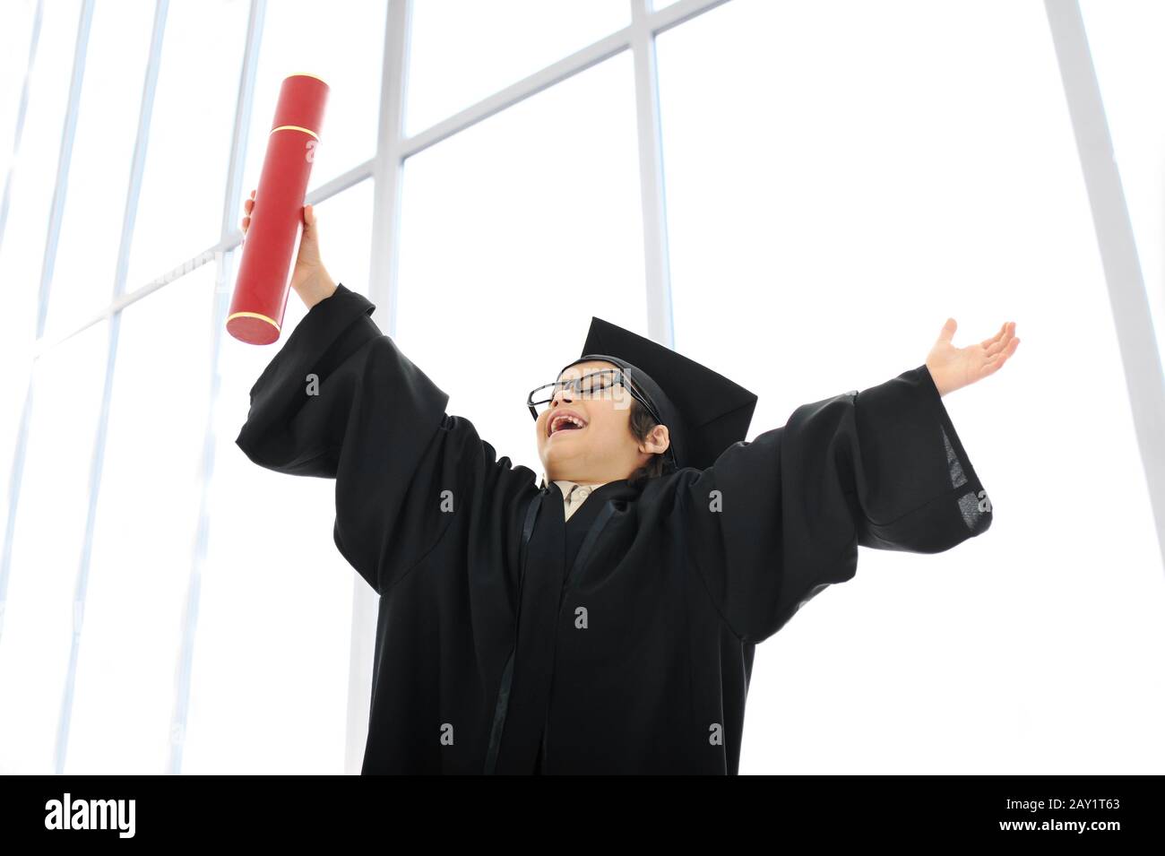 Kid celebrating graduating diploma Stock Photo - Alamy