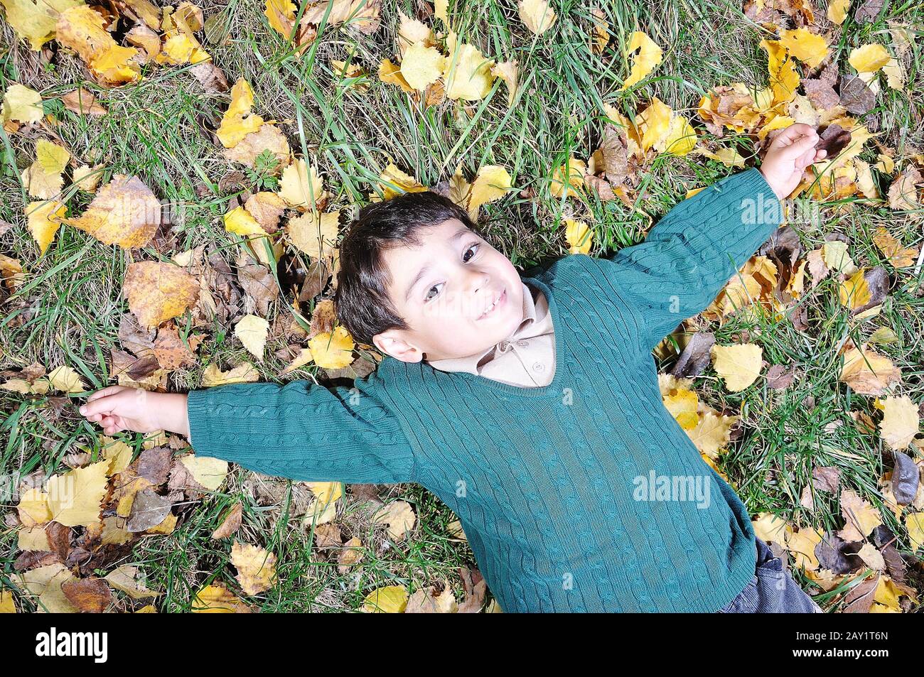 Little cute kid laying on the fall ground Stock Photo - Alamy
