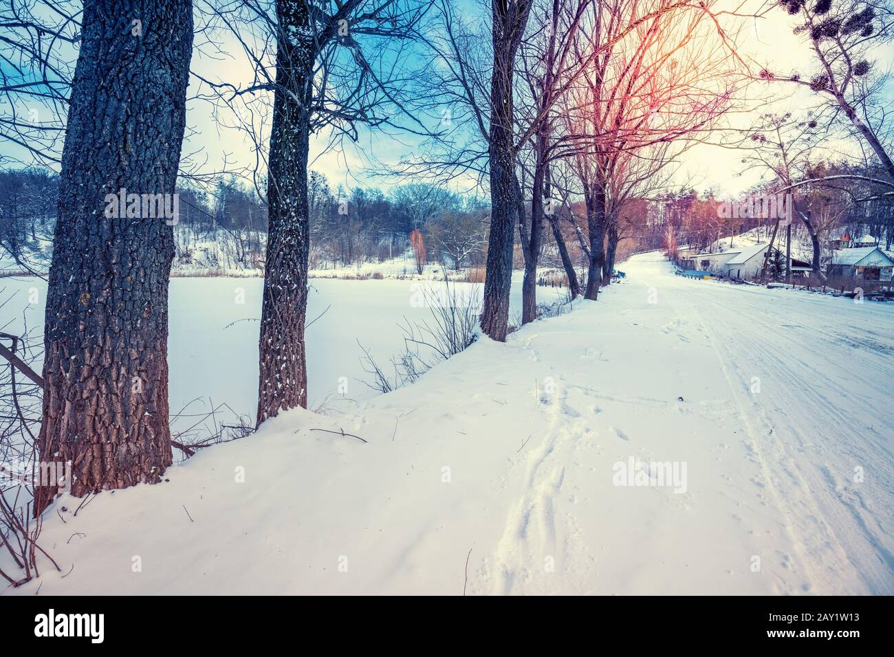 Winter snowy country road along a frozen lake Stock Photo - Alamy