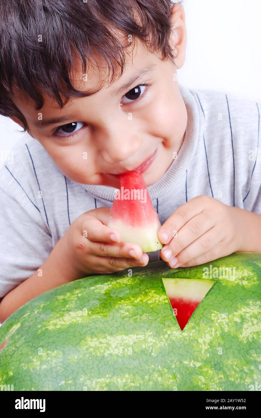 Very cute kid eating watermelon Stock Photo - Alamy