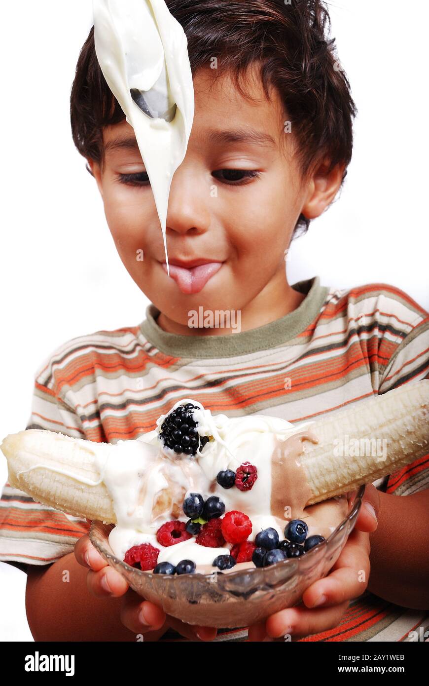 Very cute kid is about to eat very sweet mixed fruint and cream Stock ...