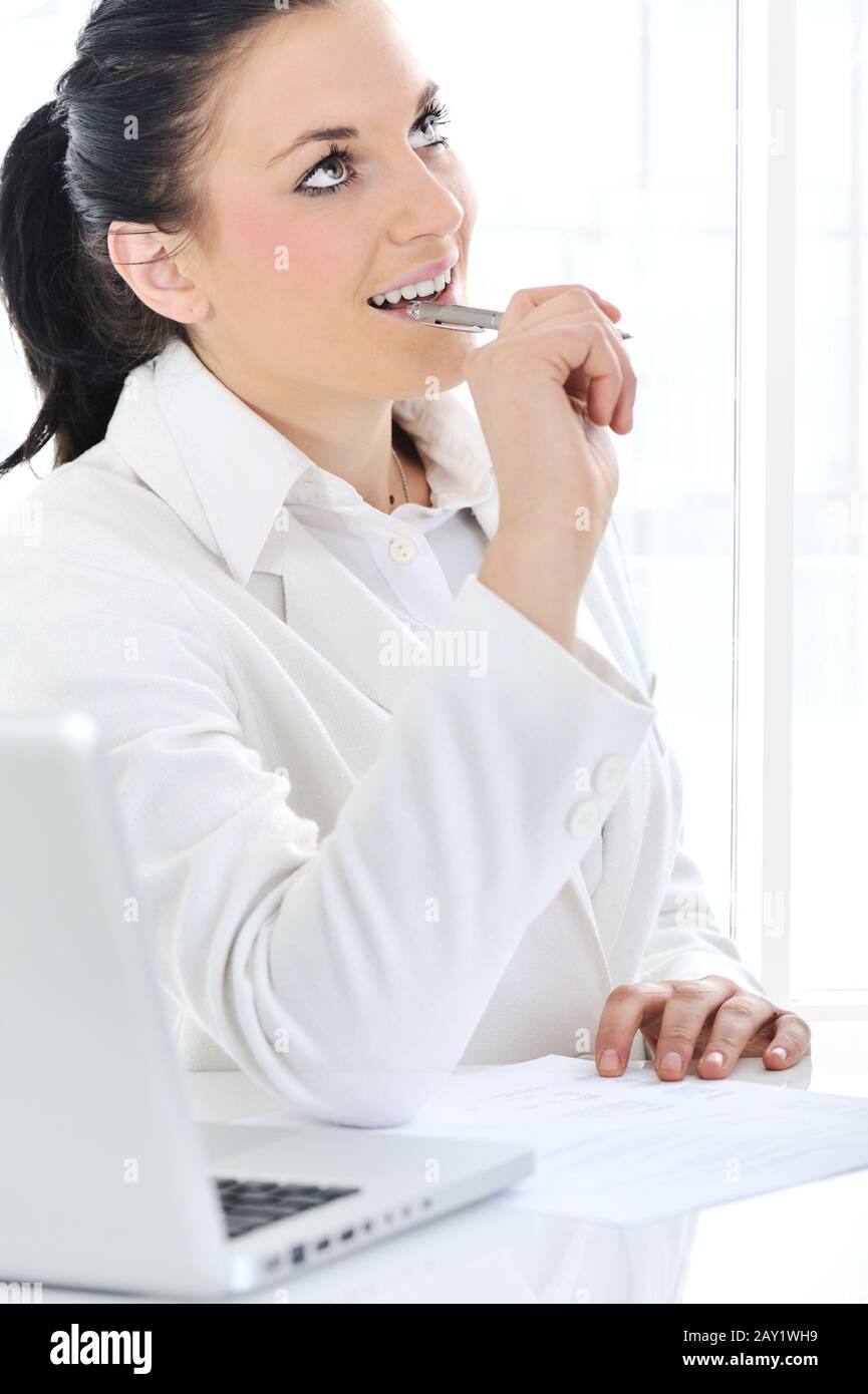 Pretty business woman thinking at office Stock Photo - Alamy