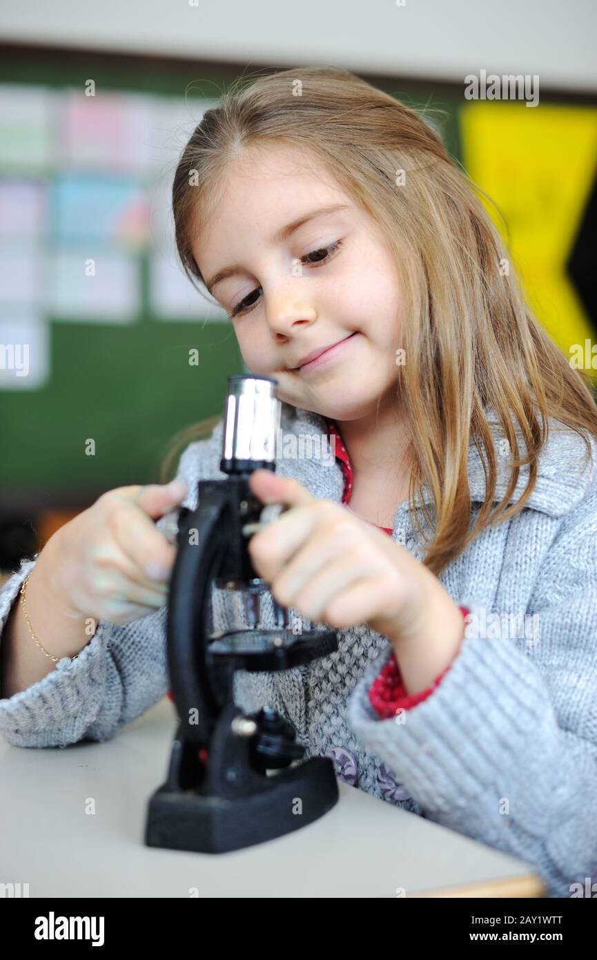Beautiful young girl with a microscope Stock Photo - Alamy