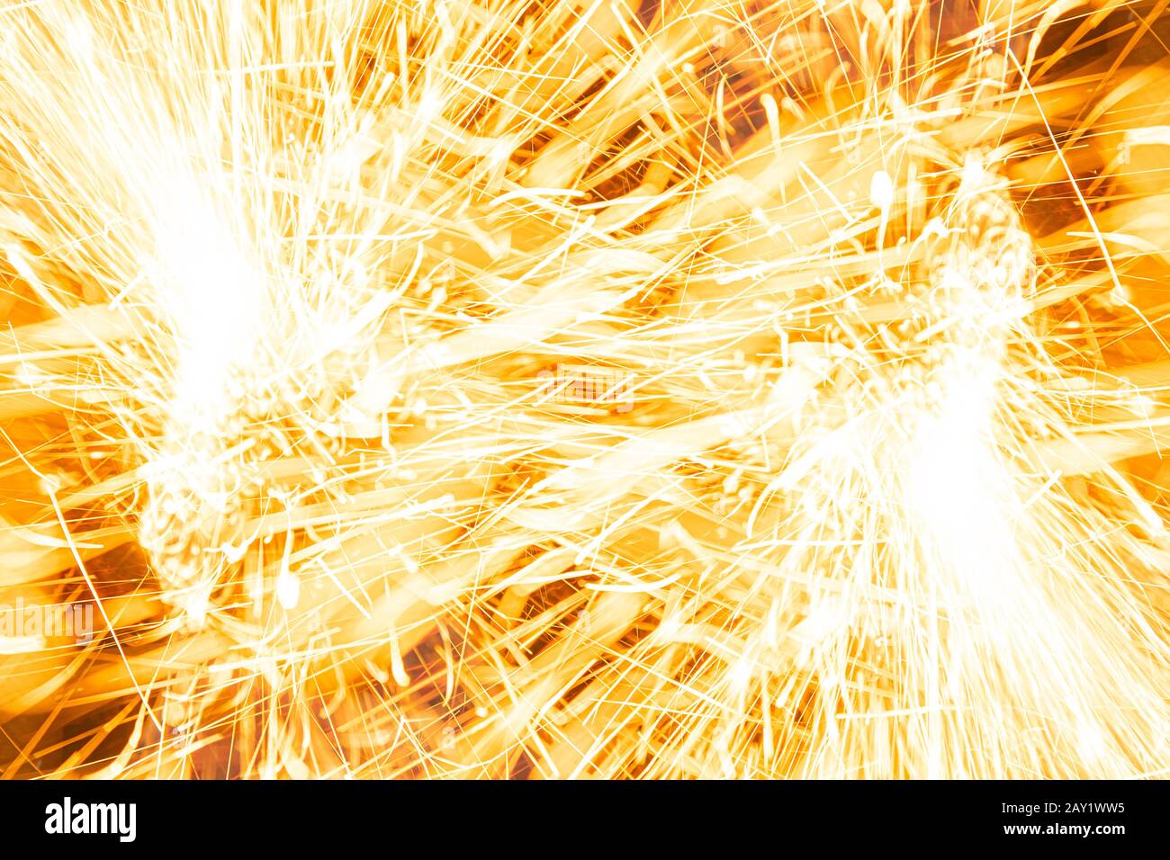 Bright orange and yellow sparks on a black background. A stream of ...