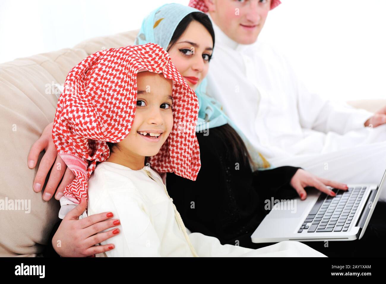 Arabic parents and little boy at home with laptop computer Stock Photo ...