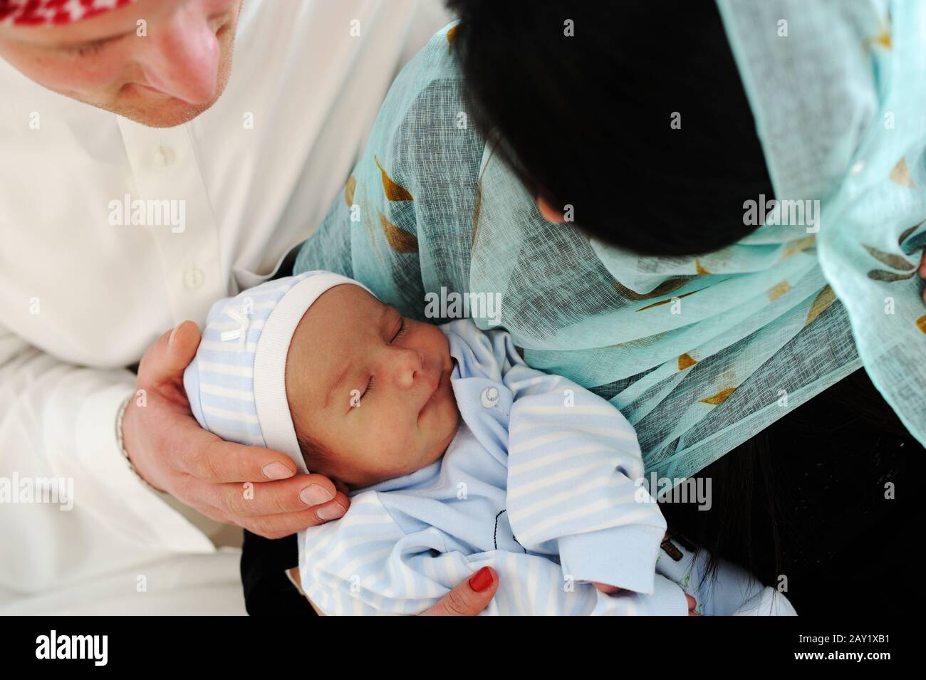 Arabic Muslim couple with new baby at home Stock Photo - Alamy