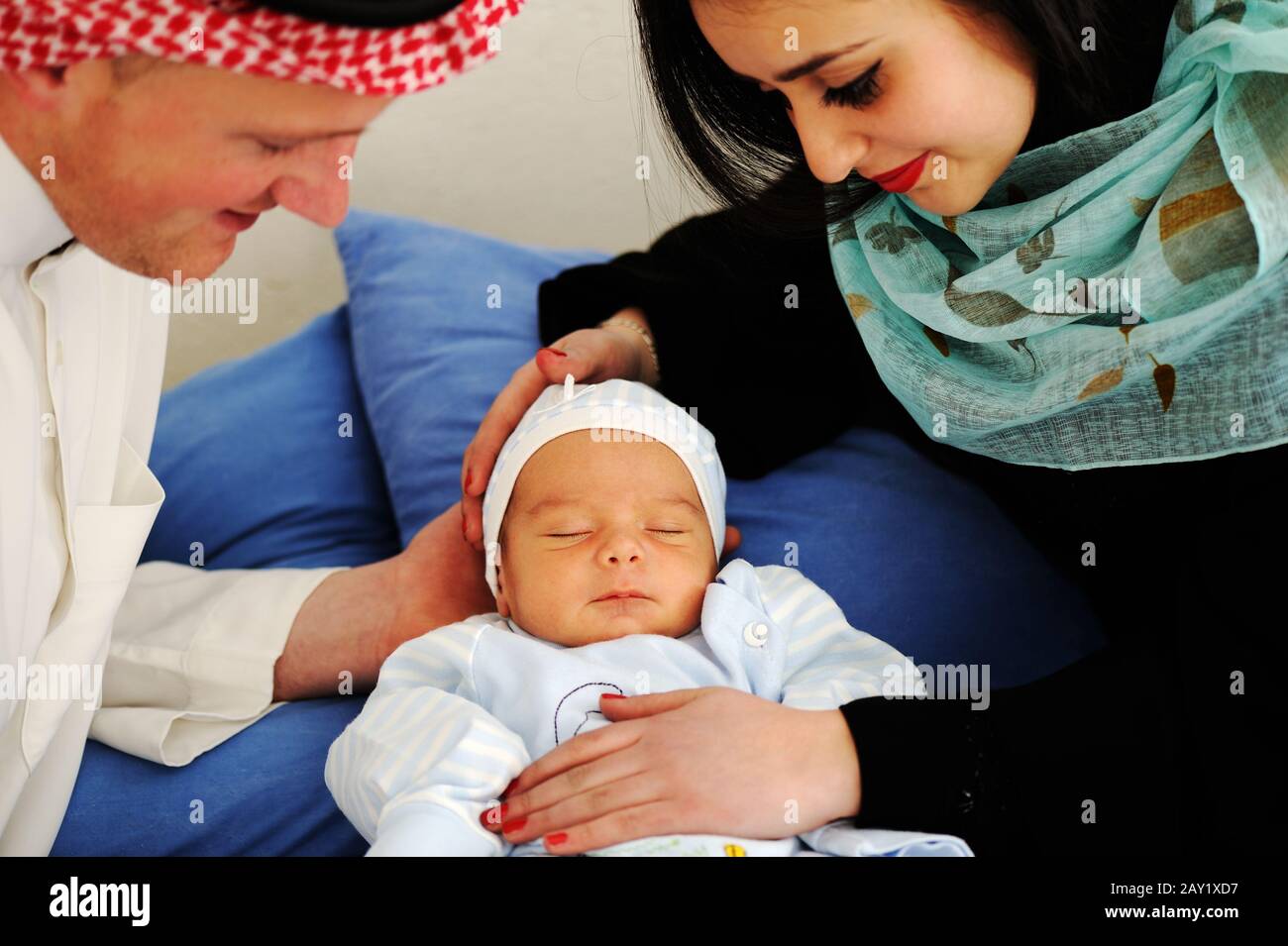Arabic Muslim couple with new baby at home Stock Photo - Alamy