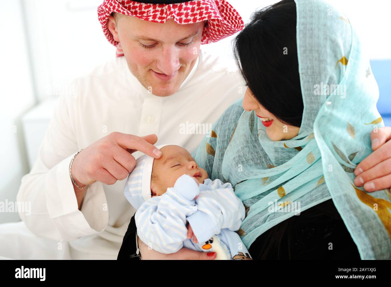 Arabic Muslim couple with new baby at home Stock Photo - Alamy