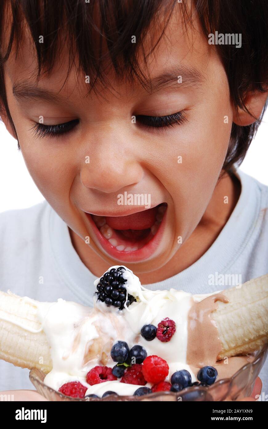 Very cute kid is about to eat very sweet mixed fruint and cream Stock ...