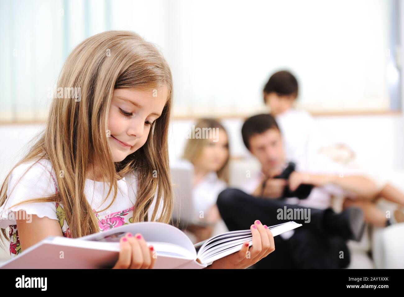 Little girl reading in home Stock Photo - Alamy