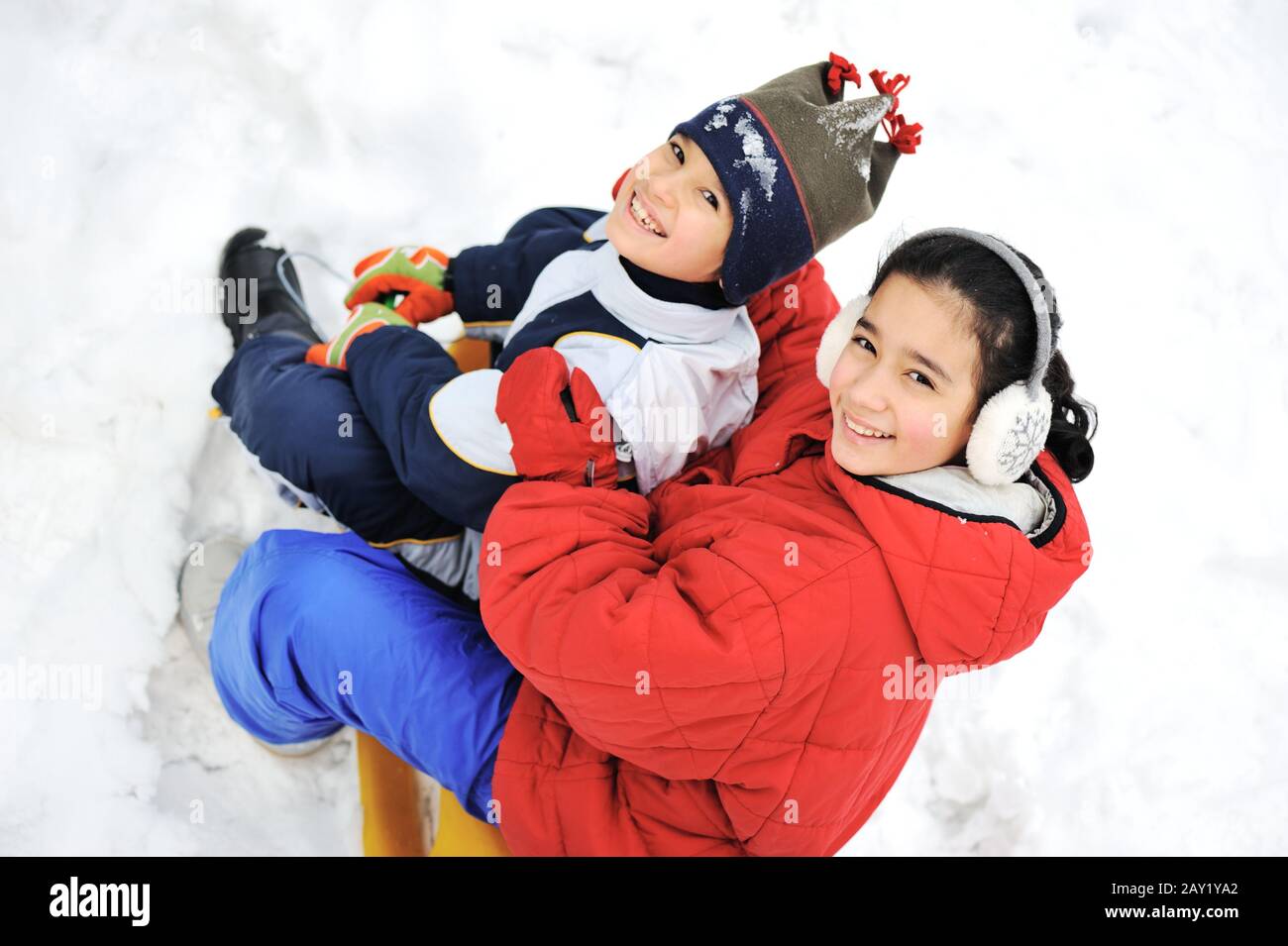 Kids sliding sledge in the snow Stock Photo - Alamy