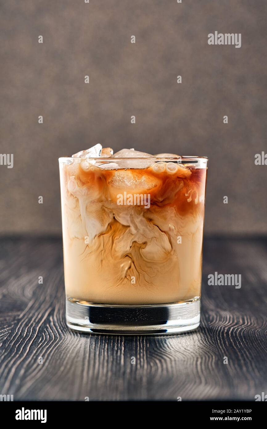 Iced coffee with cream on dark wooden background Stock Photo - Alamy
