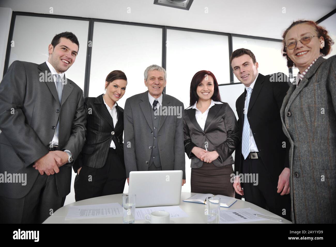 Multi aged business people standing around the table at office Stock ...
