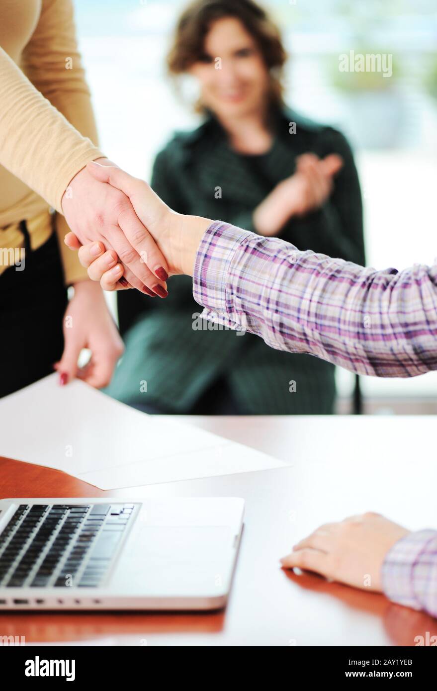 Closing a successful deal with a handshake. Signed contract and ...
