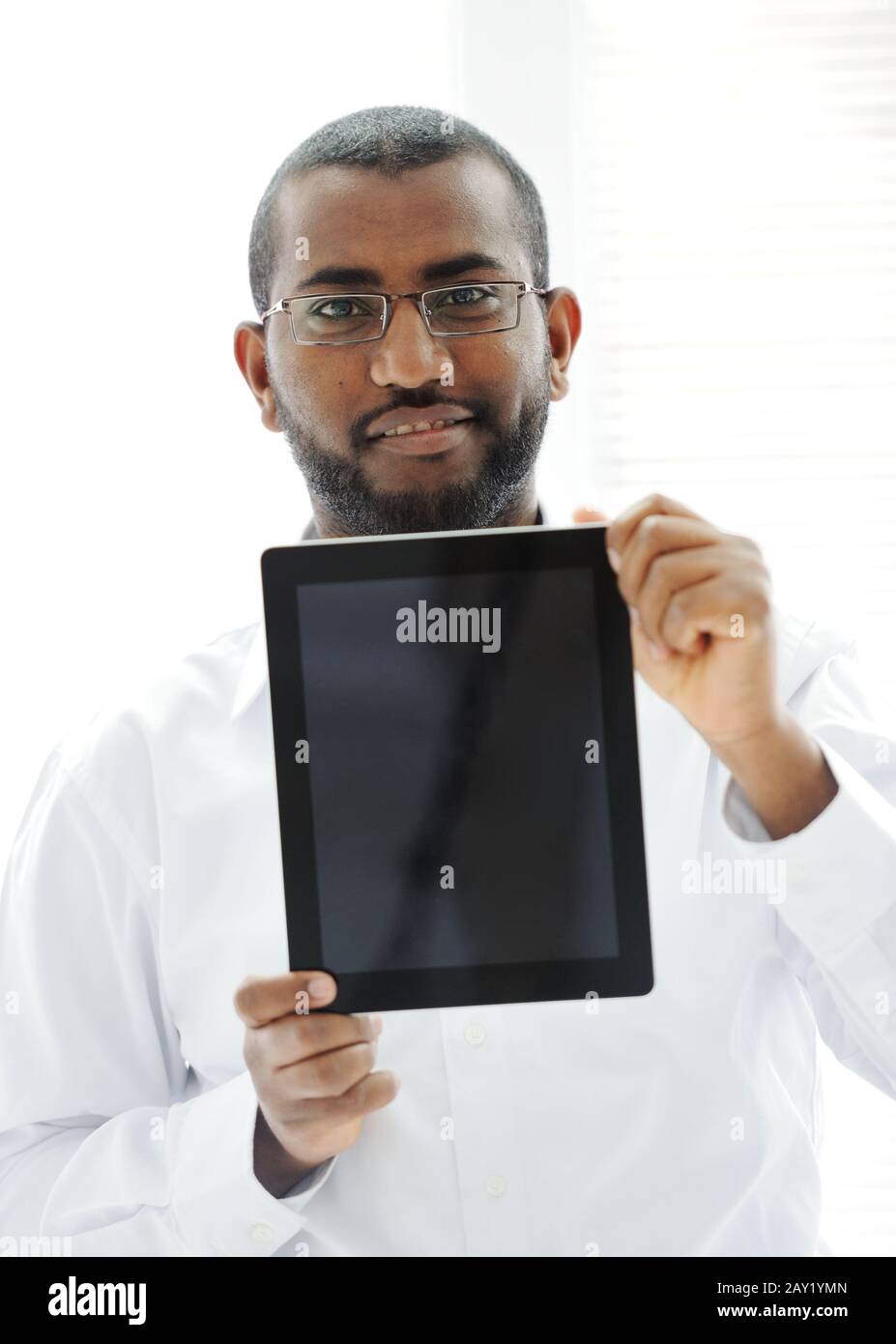 African man holding tablet ready for your message Stock Photo - Alamy