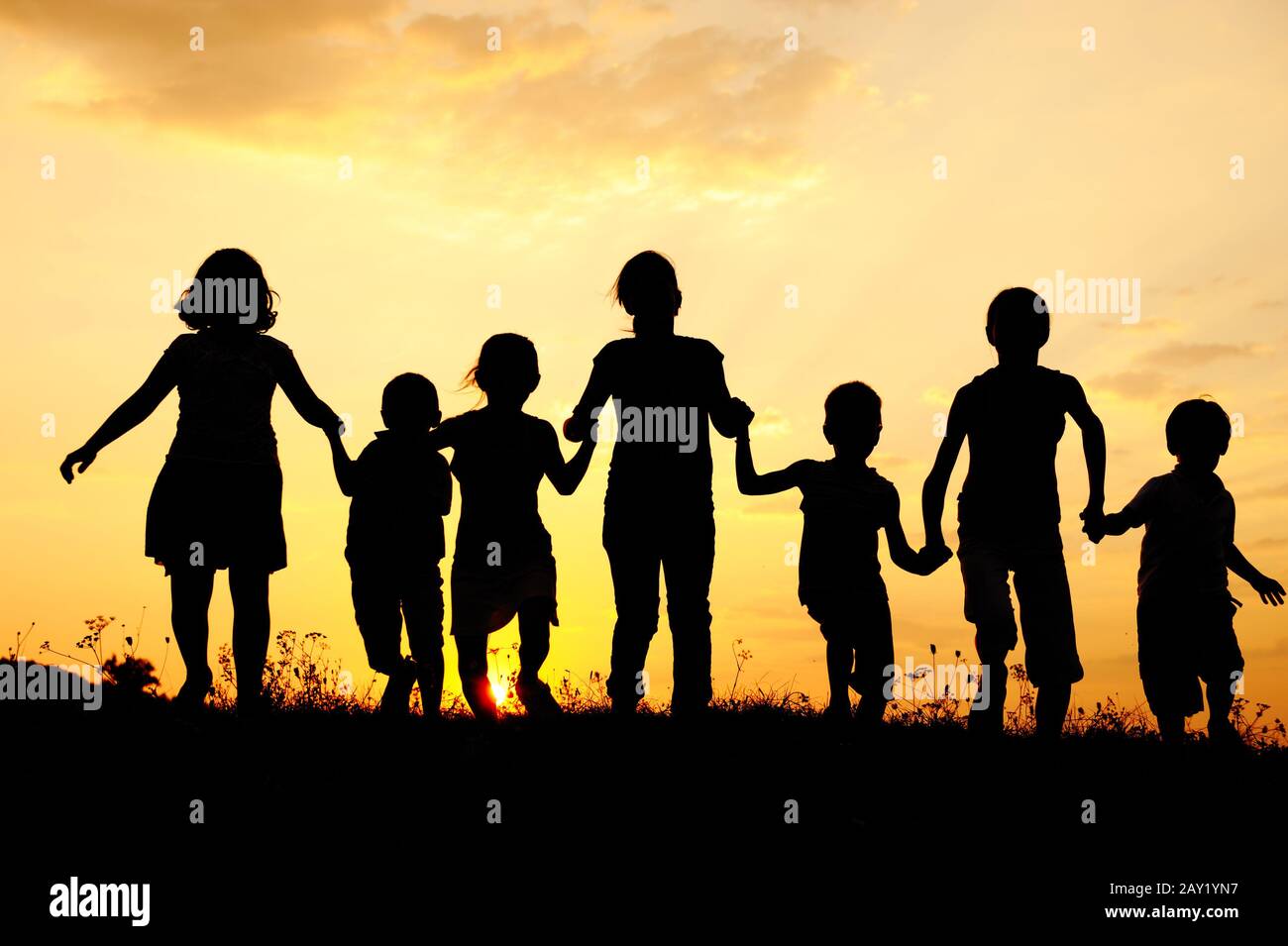 Children running on meadow at sunset Stock Photo - Alamy
