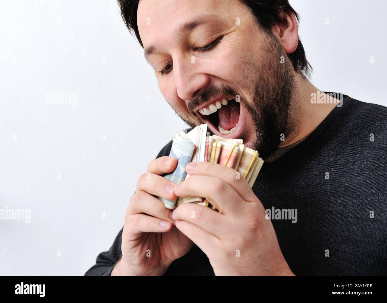 Man eating money Stock Photo - Alamy