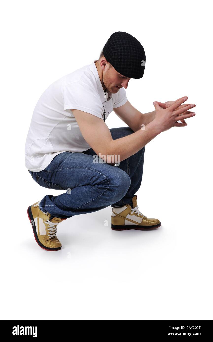 Young man crouching Stock Photo - Alamy