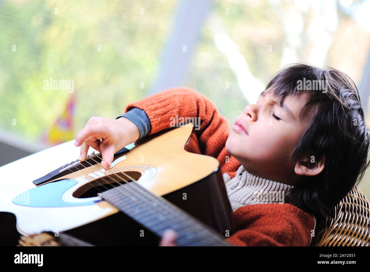 Little boy playing guitar at home Stock Photo - Alamy