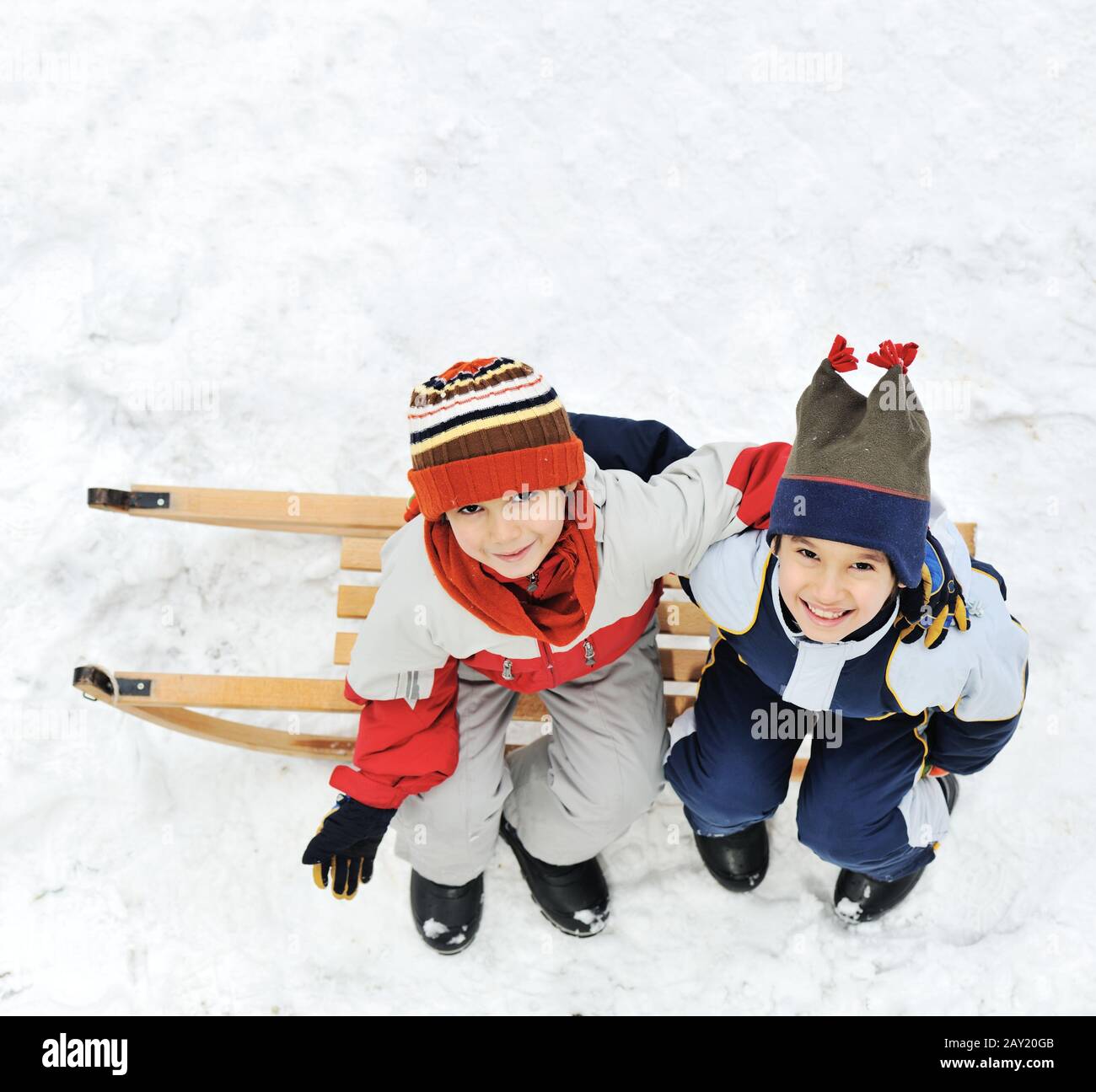 Happy two little boys sitting on sledge Stock Photo - Alamy
