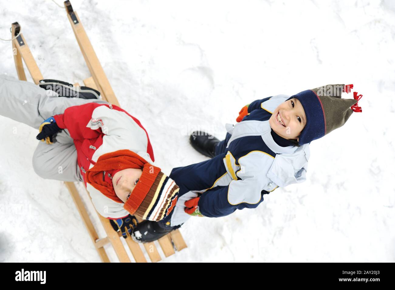 Kids sliding sledge in the snow Stock Photo - Alamy