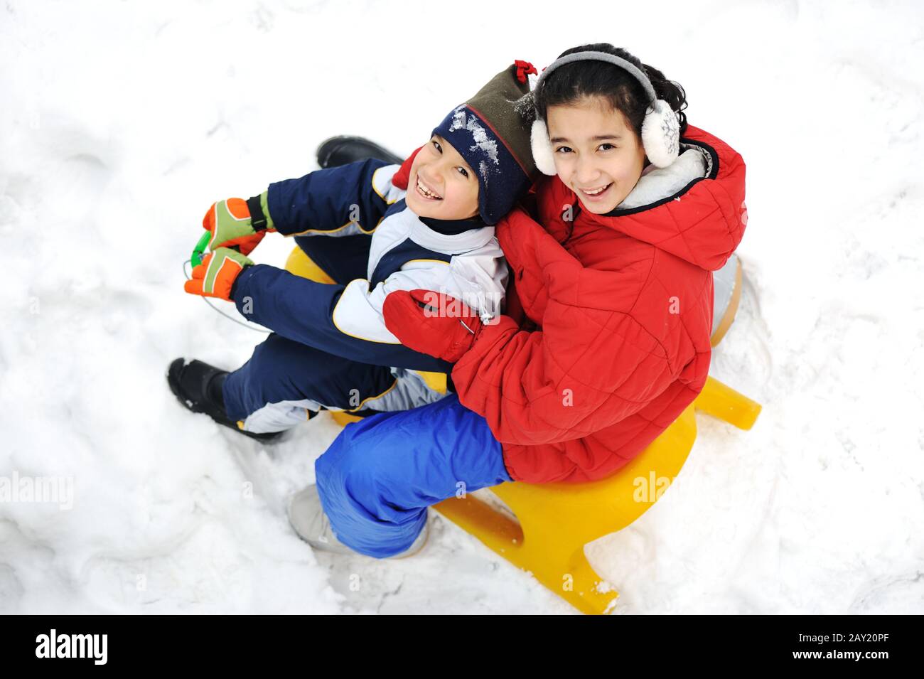 Kids sliding sledge in the snow Stock Photo - Alamy