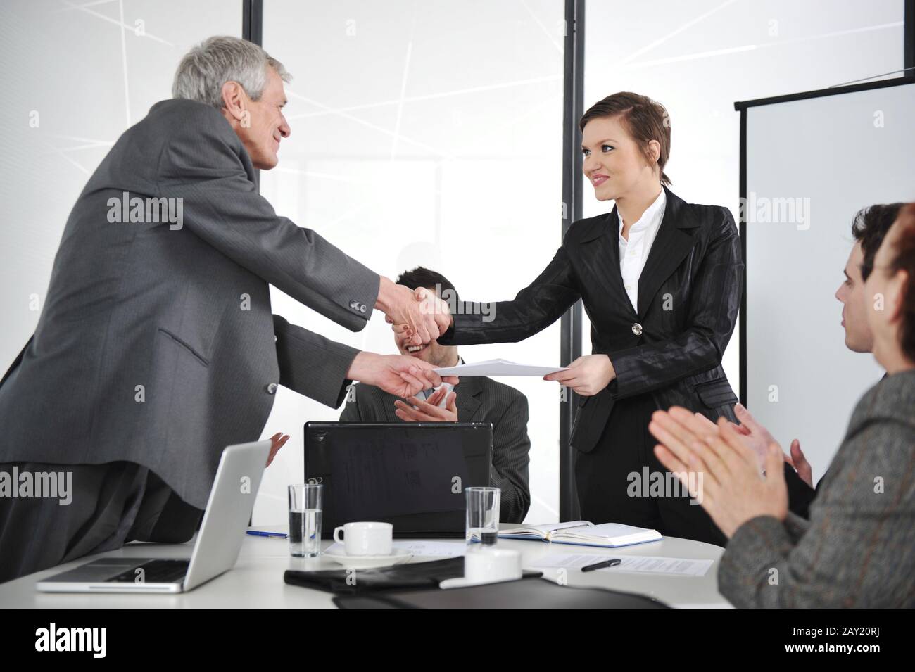 Business partners handshaking at meeting and receiving applause Stock ...