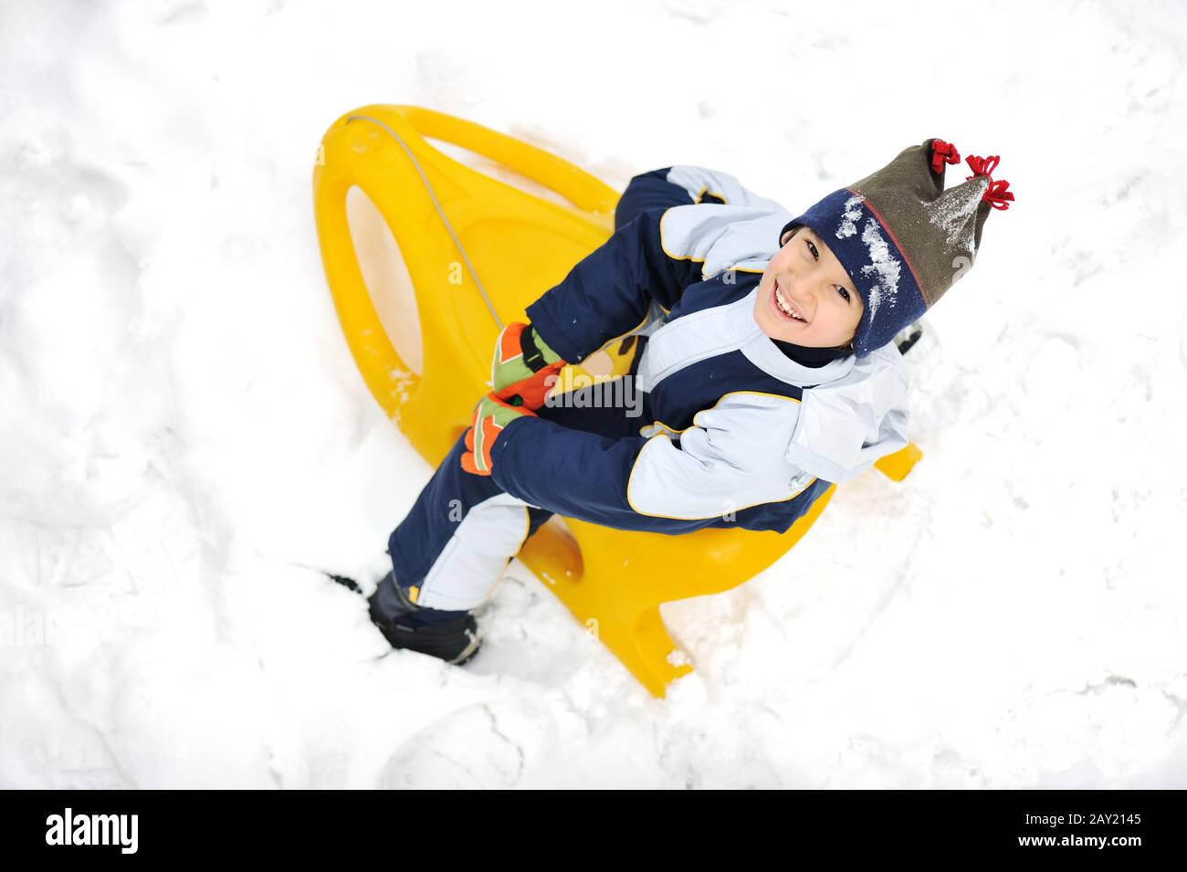 Kids sliding sledge in the snow Stock Photo - Alamy
