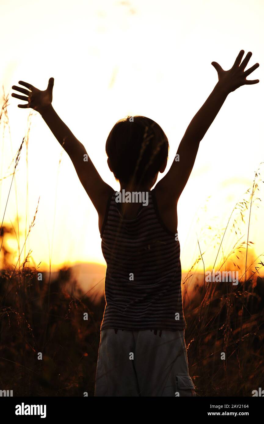 Happy kid enjoying in nature at sunset Stock Photo - Alamy
