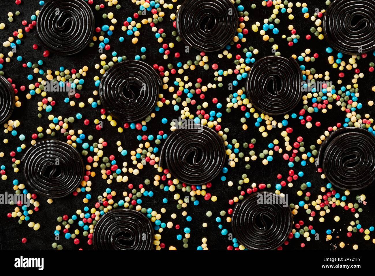 Spiral liquorice coils interspersed with colorful sugar pearls over a ...