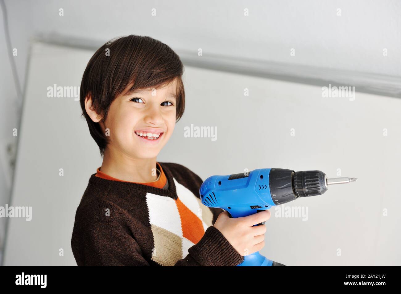 Kid with drill tool Stock Photo - Alamy