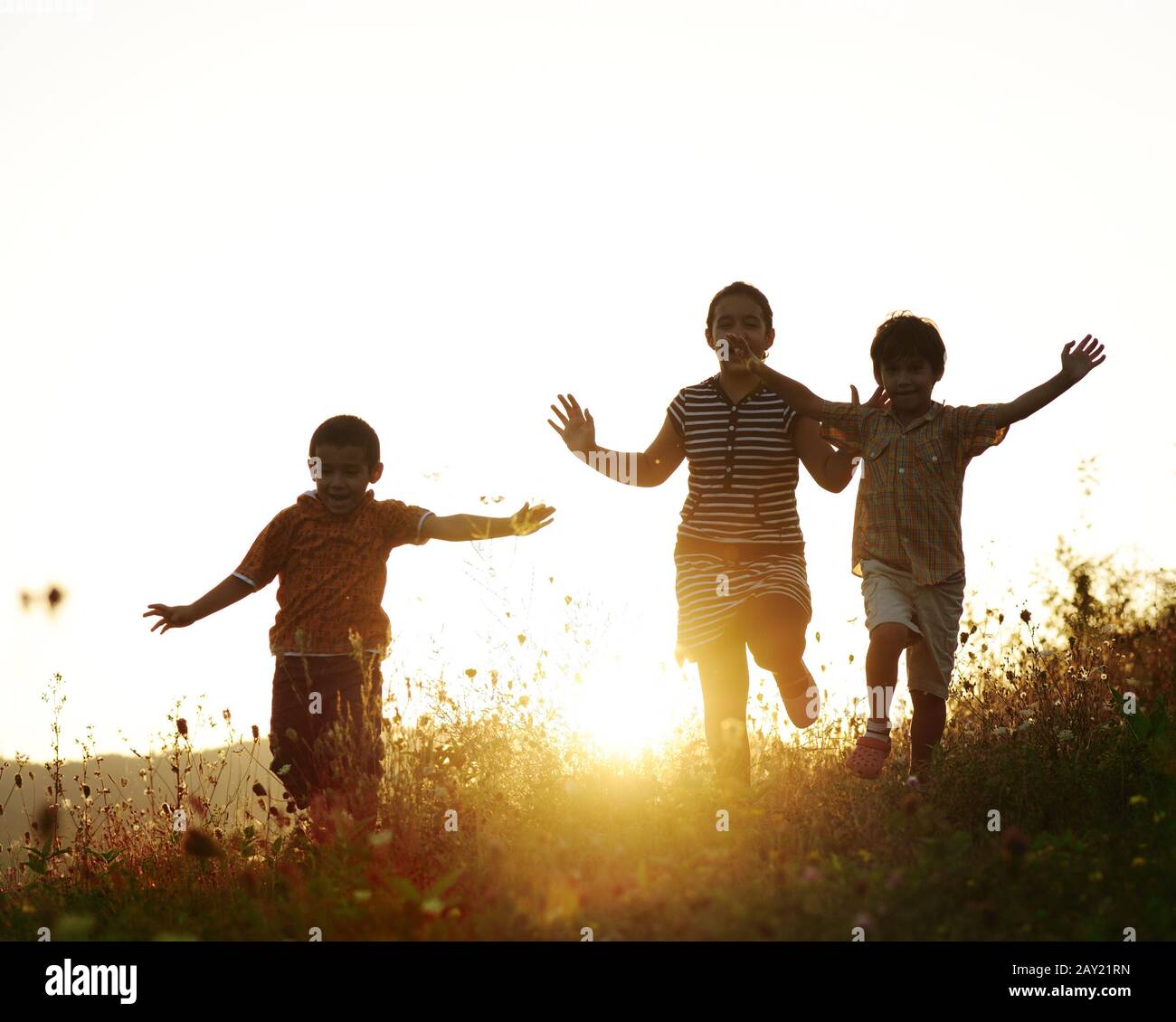 Children running on meadow at sunset Stock Photo - Alamy