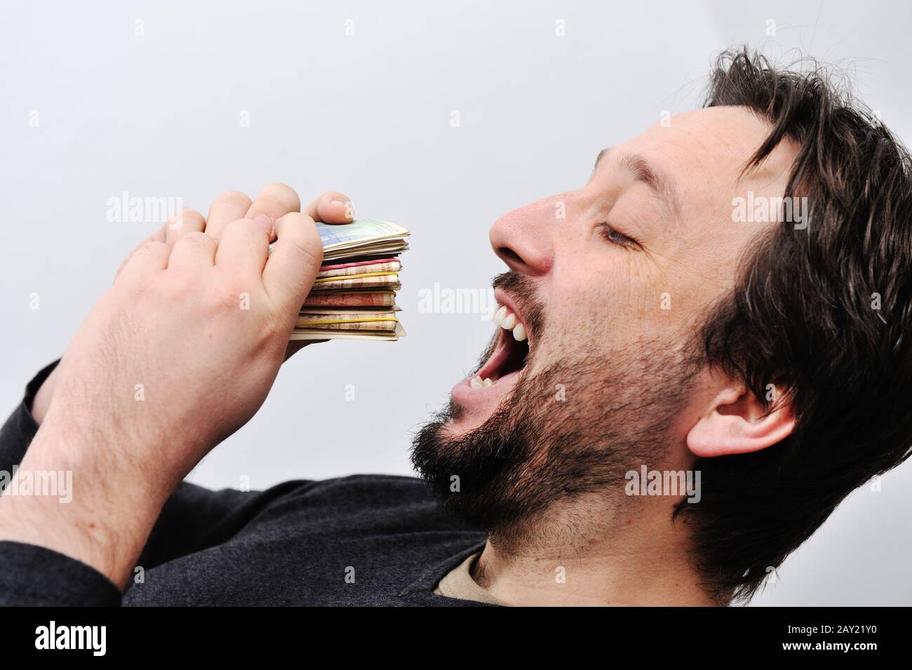 Man eating money Stock Photo - Alamy