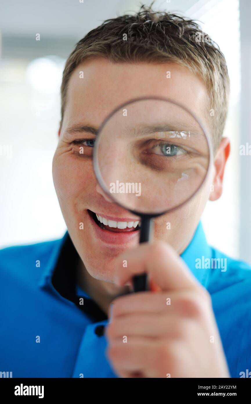 Portrait of a young business man with magnifying glass Stock Photo - Alamy