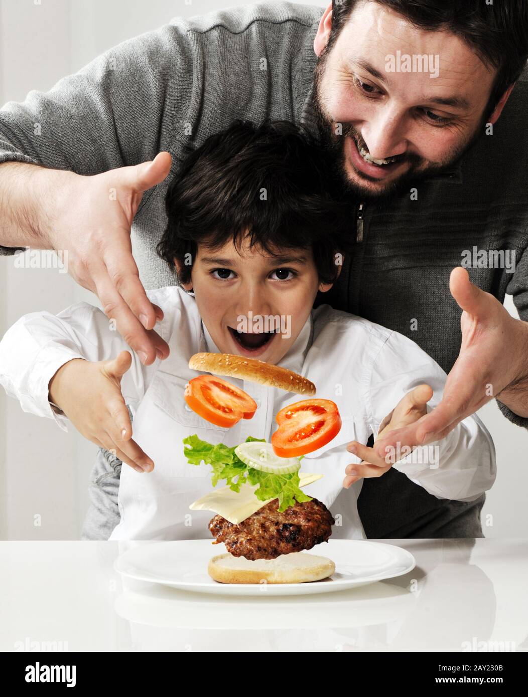 Kid and father making burger together Stock Photo - Alamy