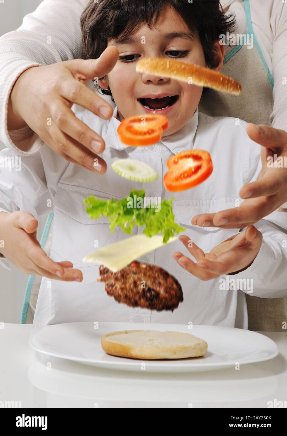 Mother and son making burger at kitchen Stock Photo - Alamy