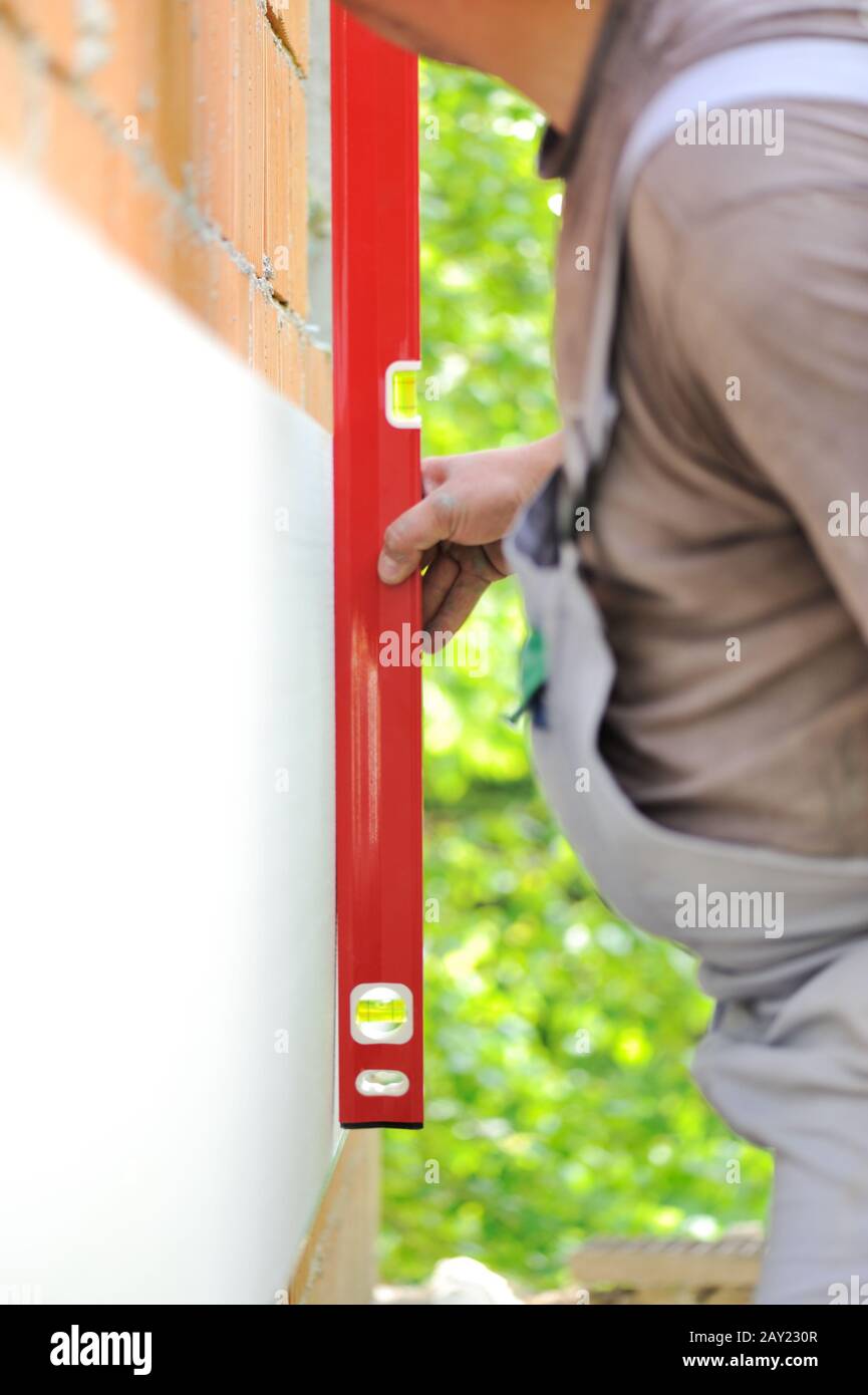 Construction worker checking vertical level with leveling tool Stock ...