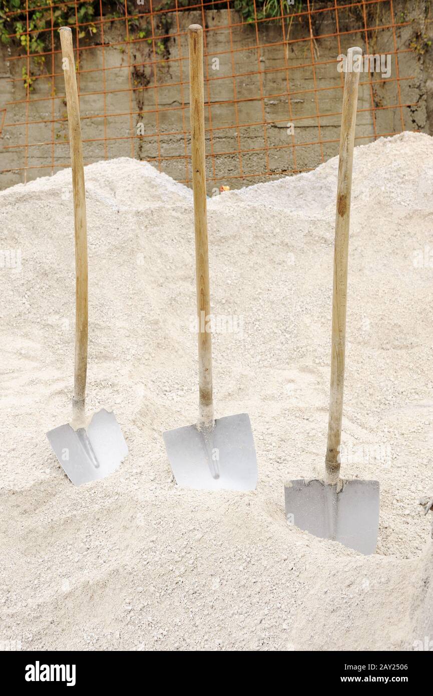 Three shovels prepared for work on sand (pedestrian Stock Photo - Alamy