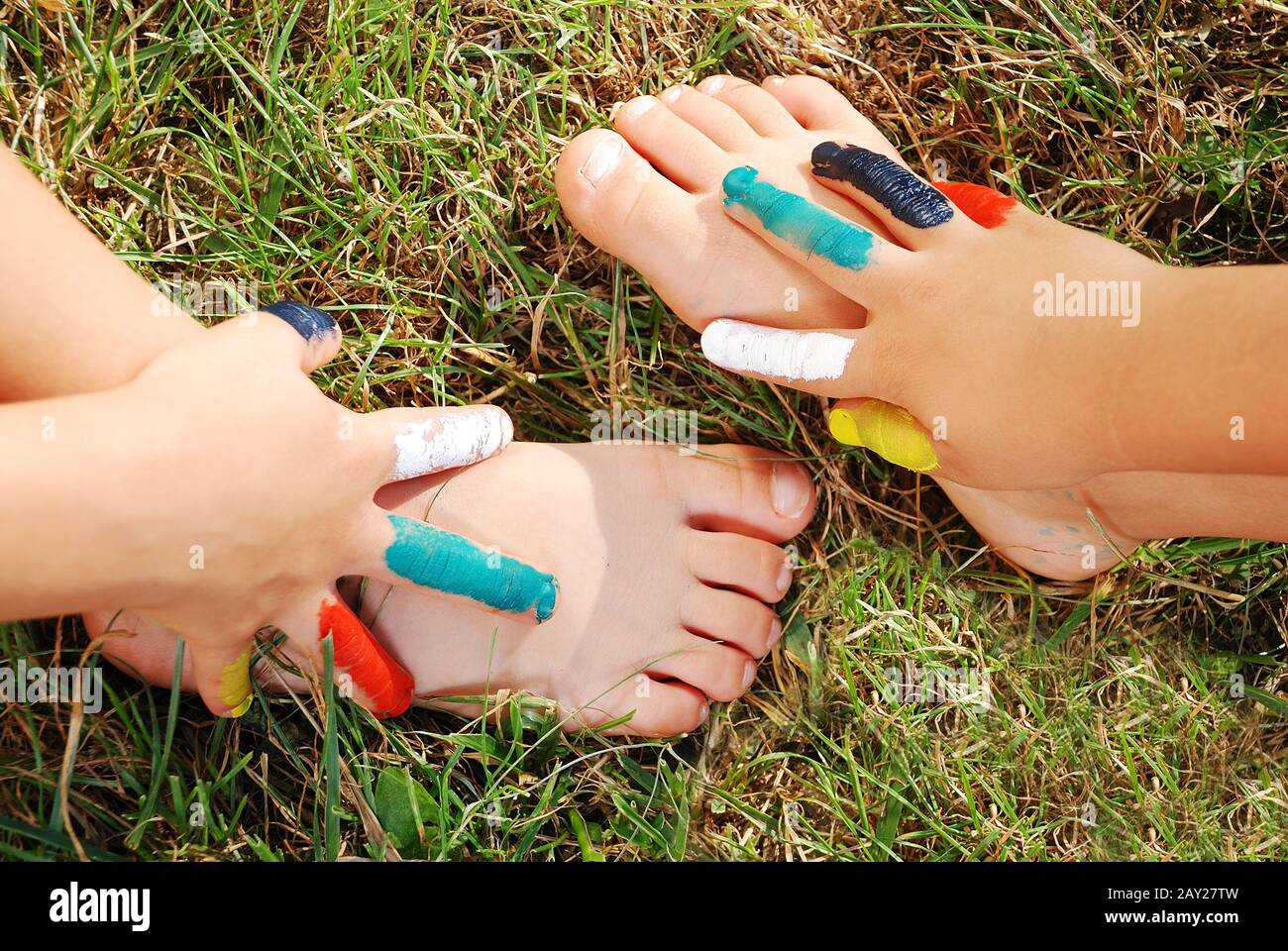 Colors on child's hand and hand on the leg Stock Photo - Alamy