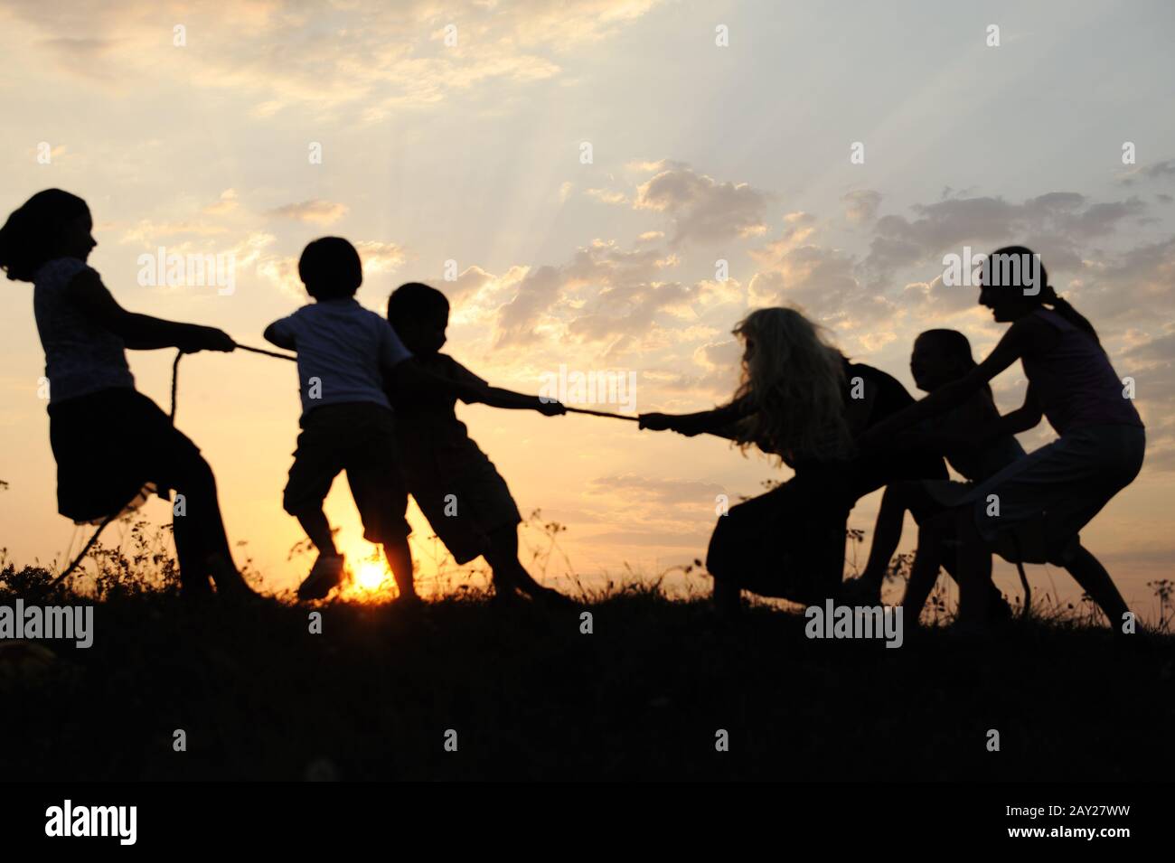 Silhouette, group of happy children playing on meadow, sunset ...